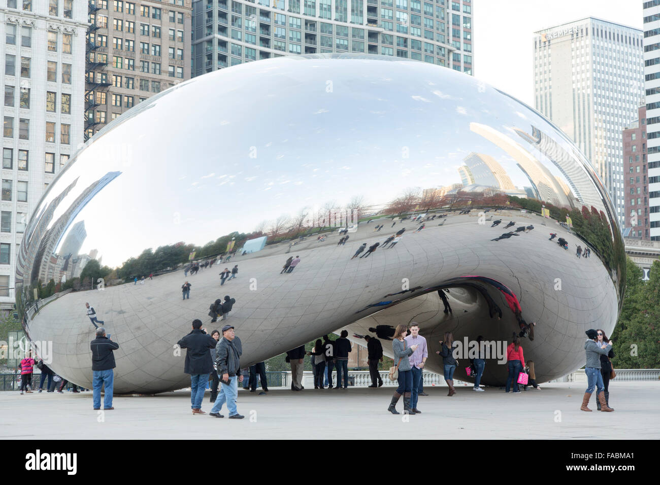 Skyline and visitors reflected in the Cloud Gate steel sculpture by ...
