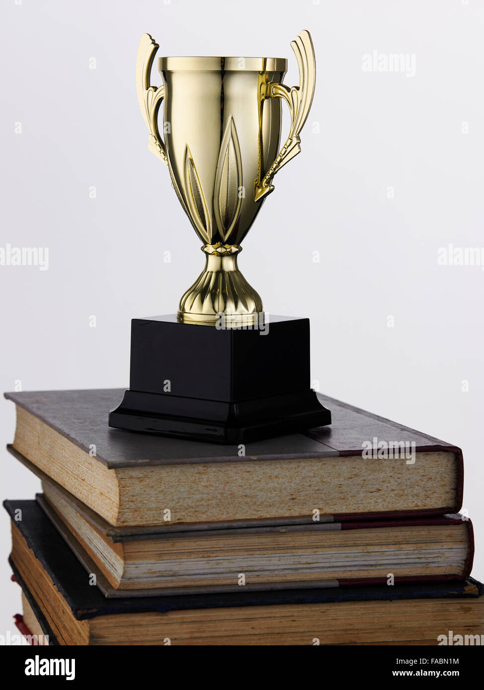 close up of a golden trophy on top of books Stock Photo - Alamy