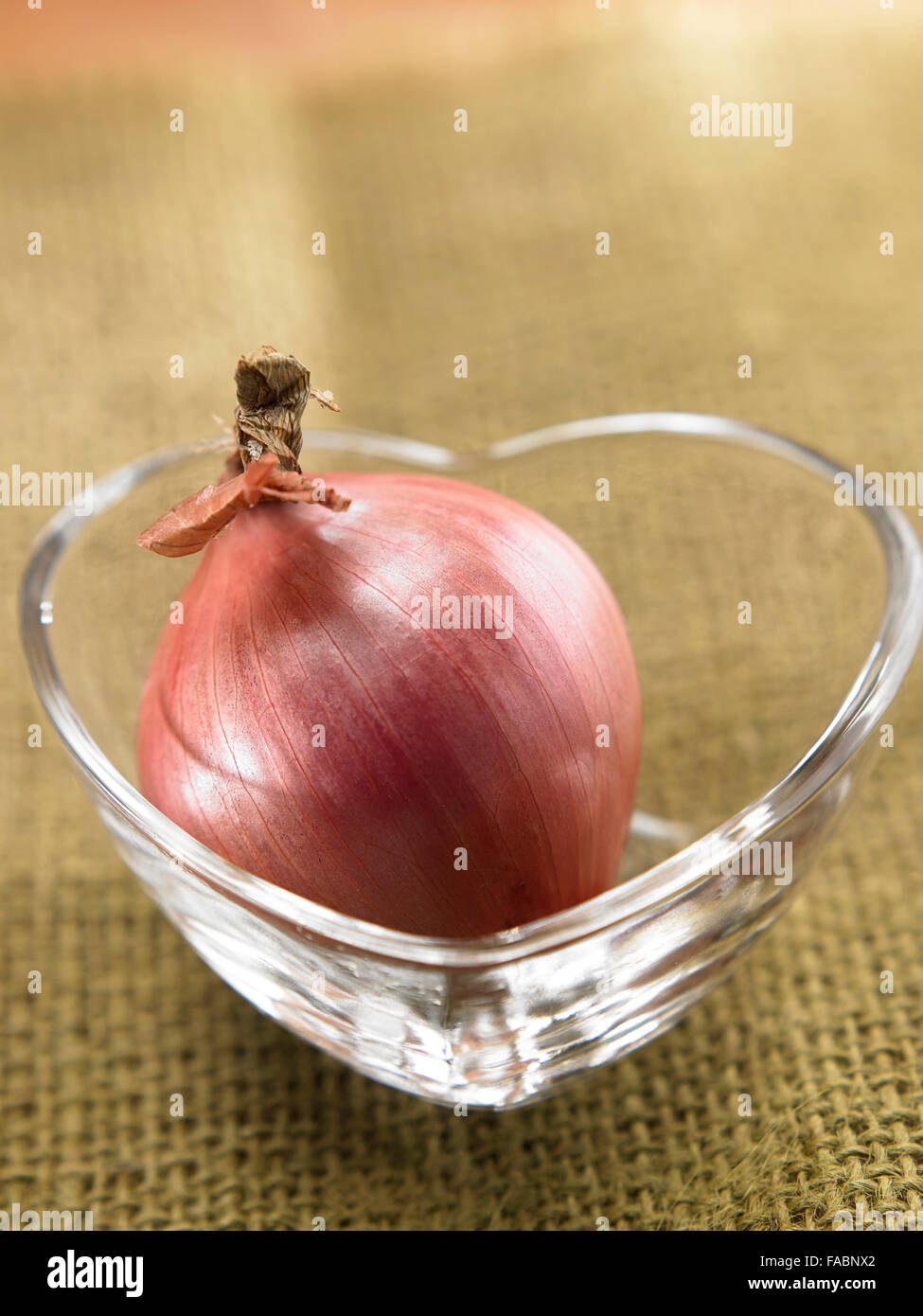 onion in the glass heart shaped bowl Stock Photo - Alamy