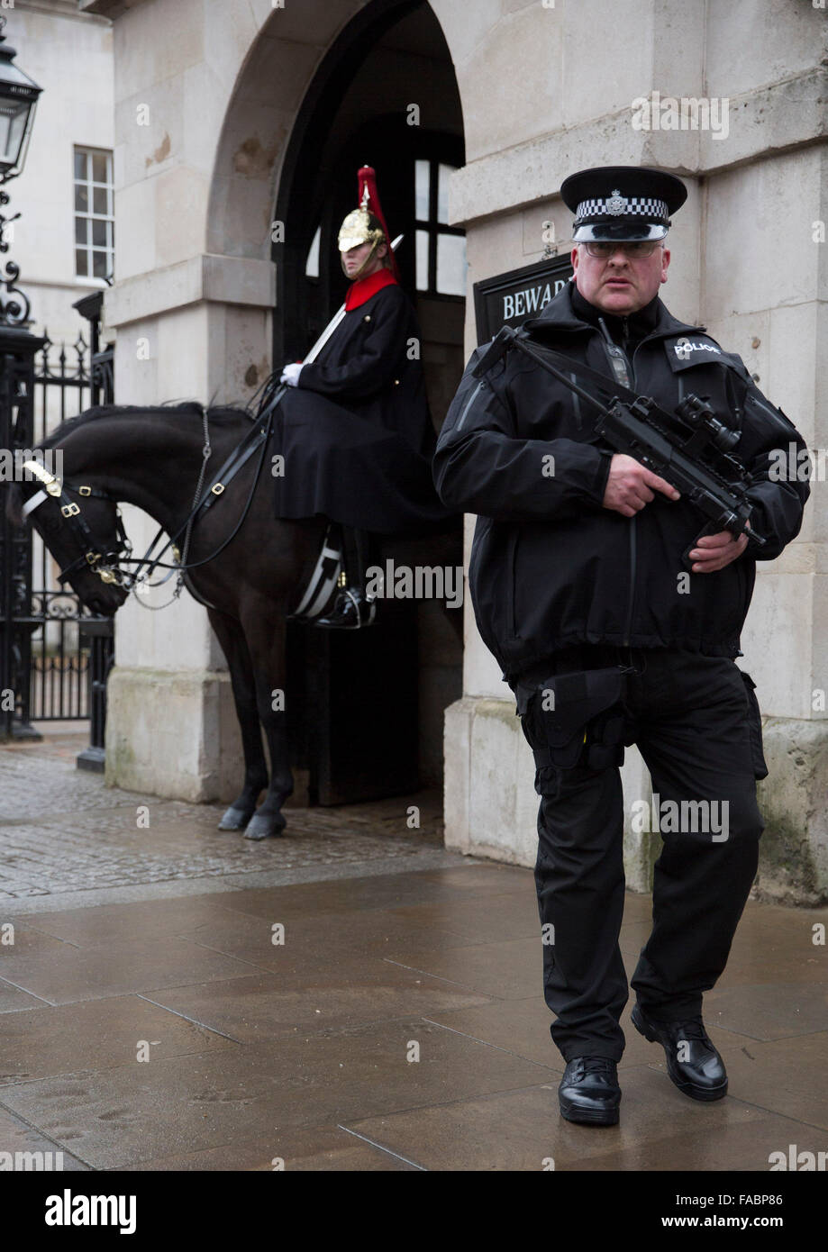 An armed British police officer patrols the streets of London Stock ...