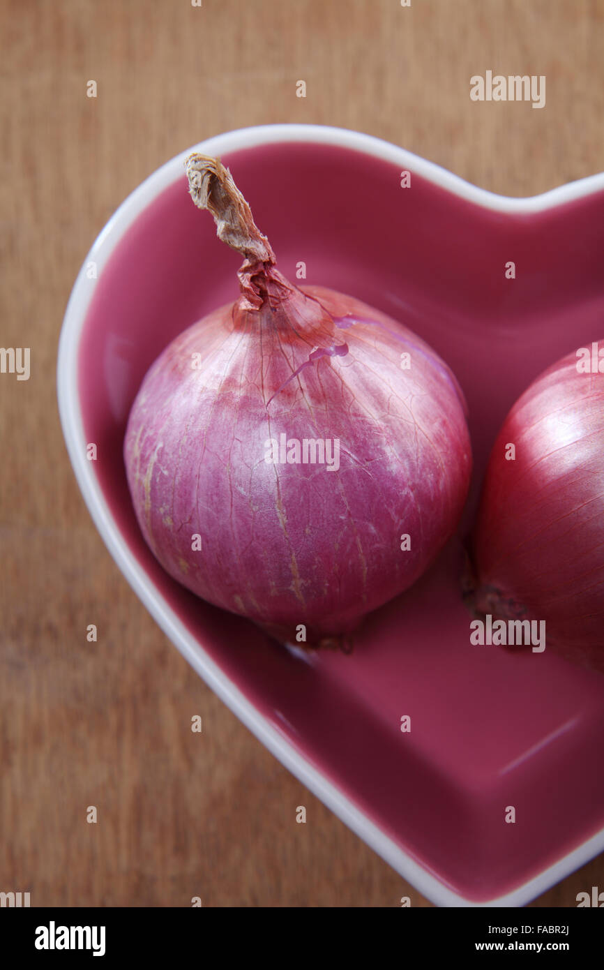 onions in a heart shaped bowl Stock Photo - Alamy