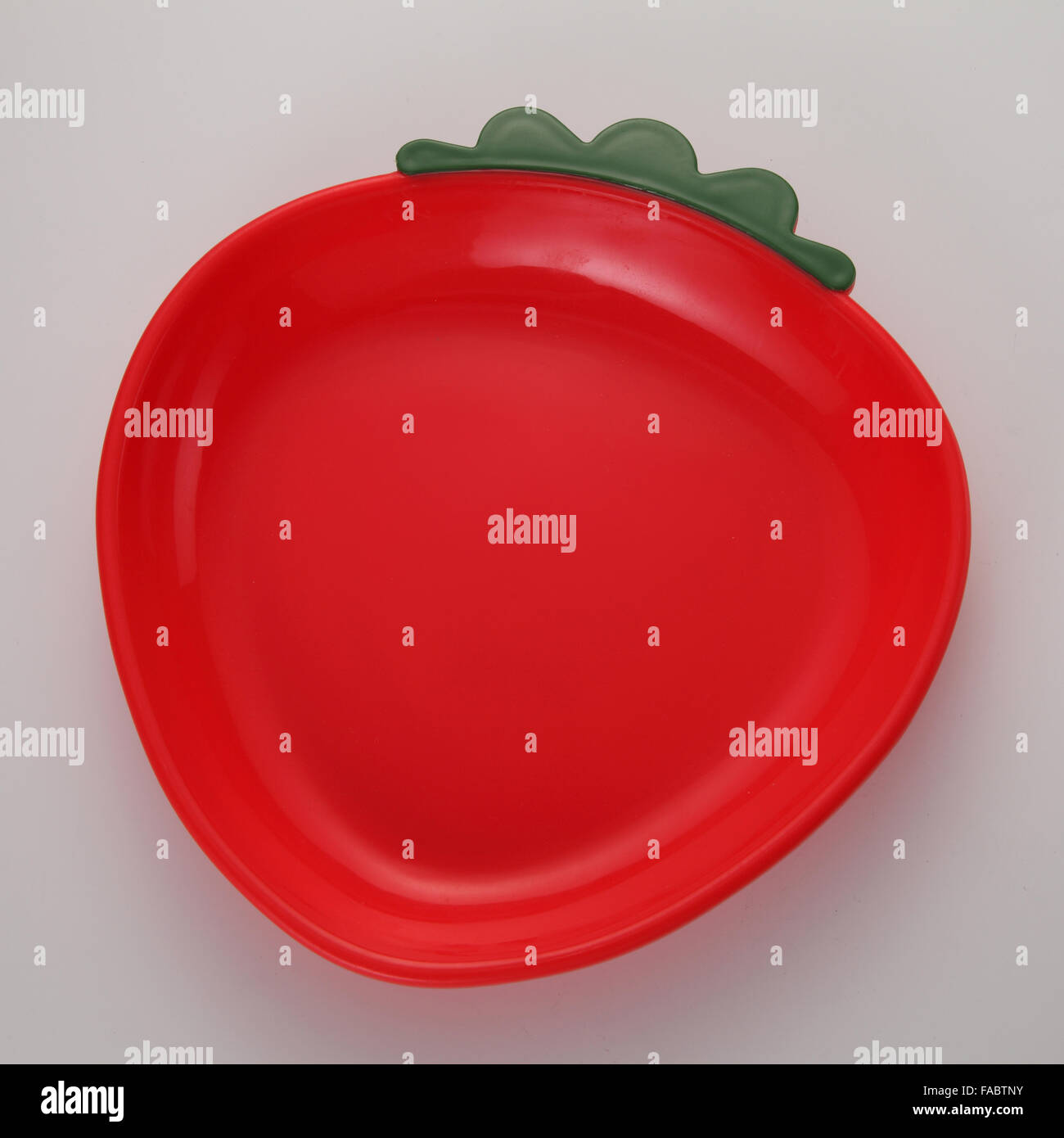 Red strawberry shaped plate on the white background Stock Photo - Alamy