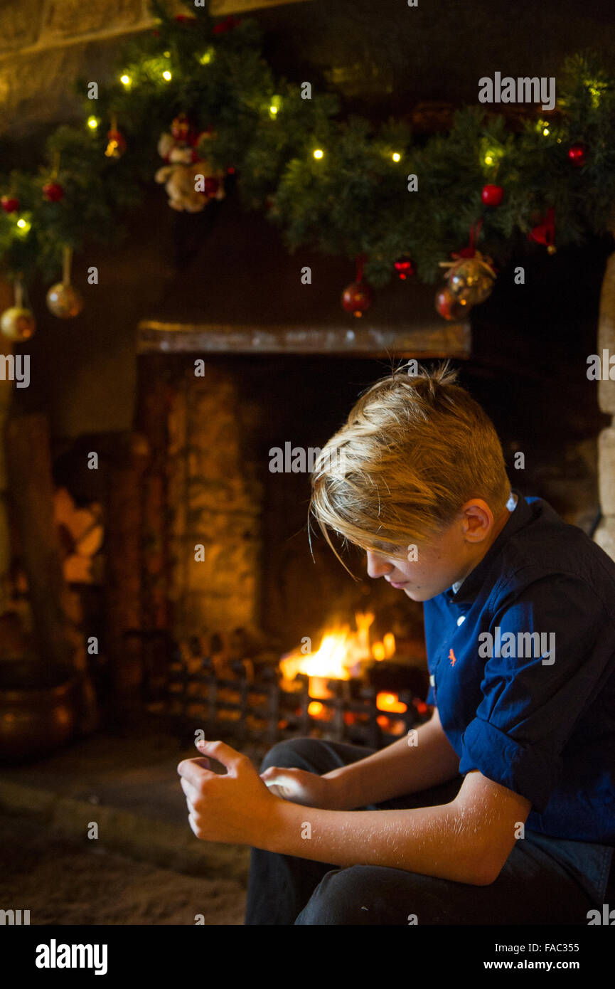 A young boy at Christmas with his new smart phone in front of an open ...