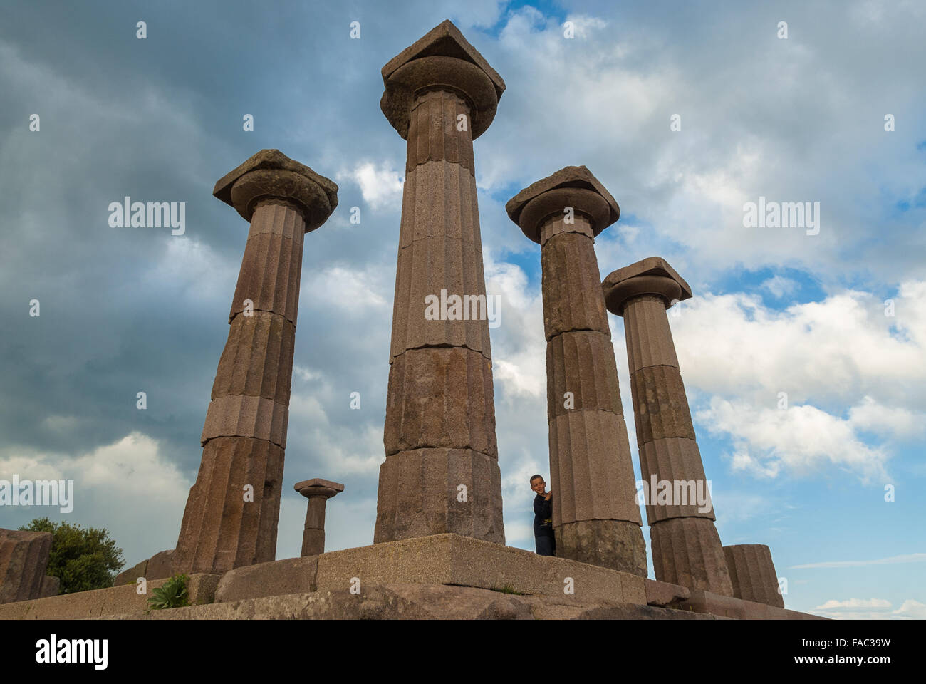 A boy hides behind a pillar of the Temple of Athena in the ...