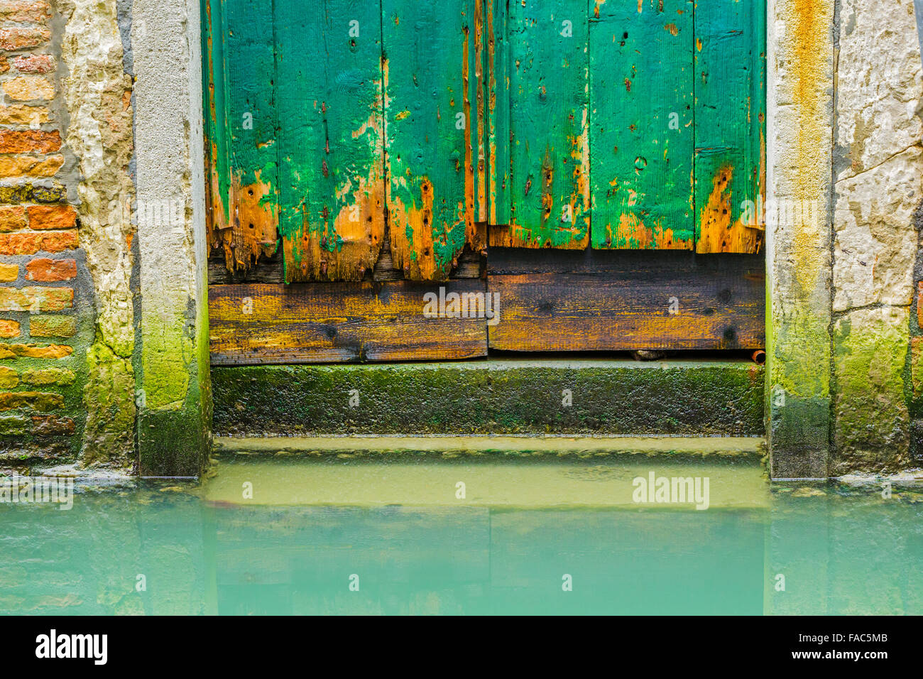 aged rustic door into canal, Venice Stock Photo - Alamy