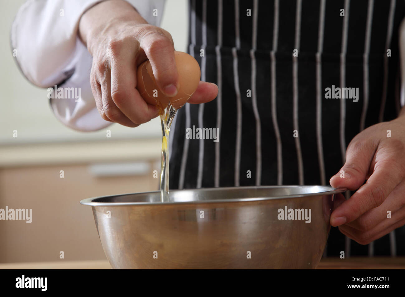 breaking a egg into mixer Stock Photo - Alamy