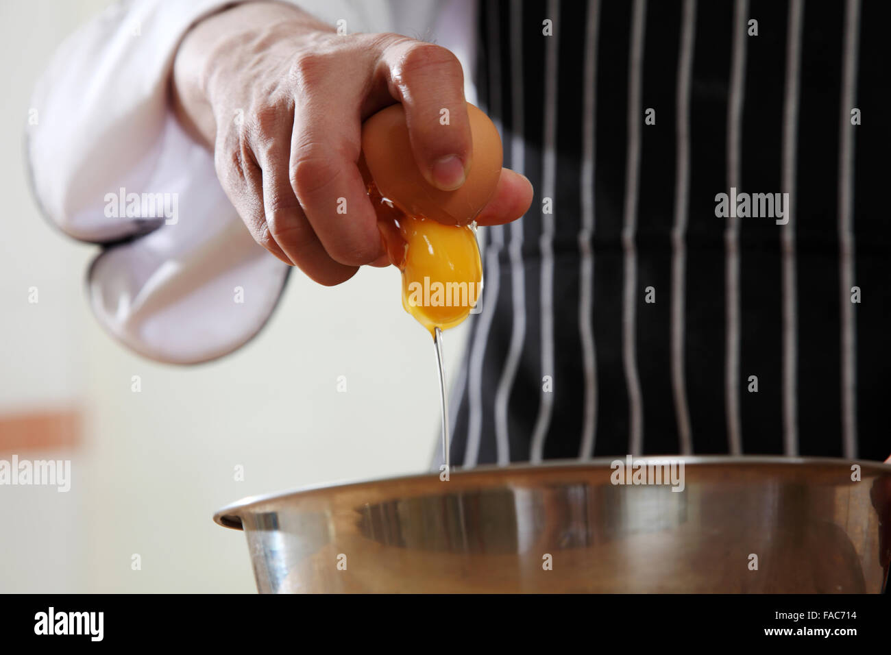 breaking a egg into mixer Stock Photo - Alamy