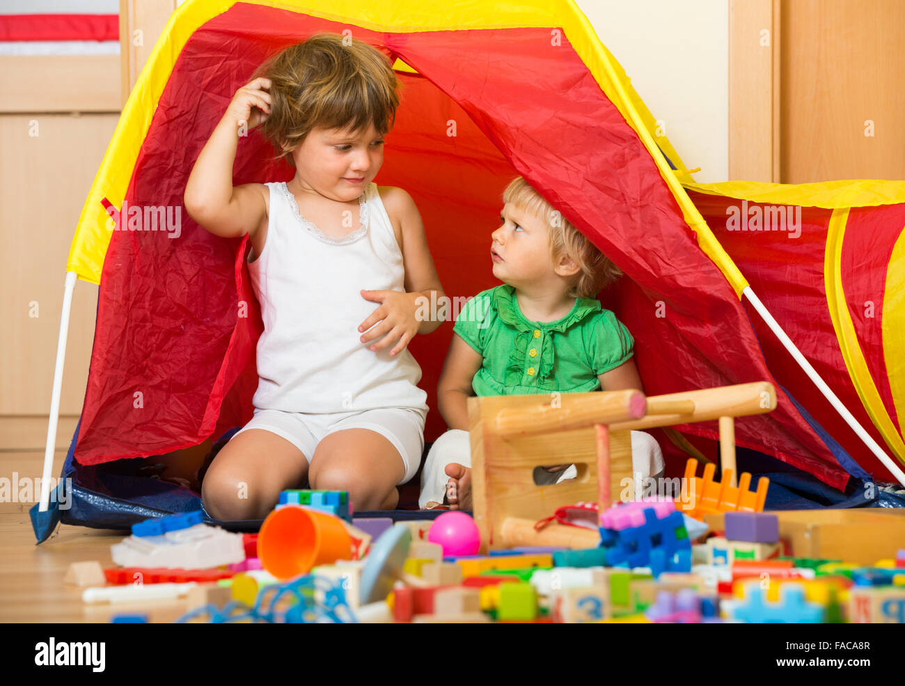 Two tranquil children playing together in home interior Stock Photo - Alamy