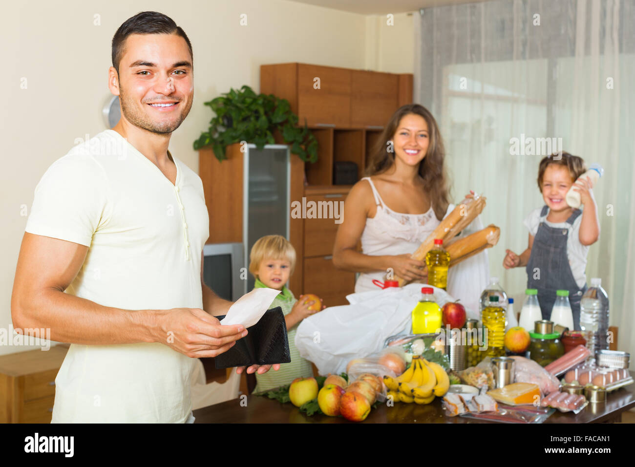 Smiling young man with receipt from store, family brought food home ...