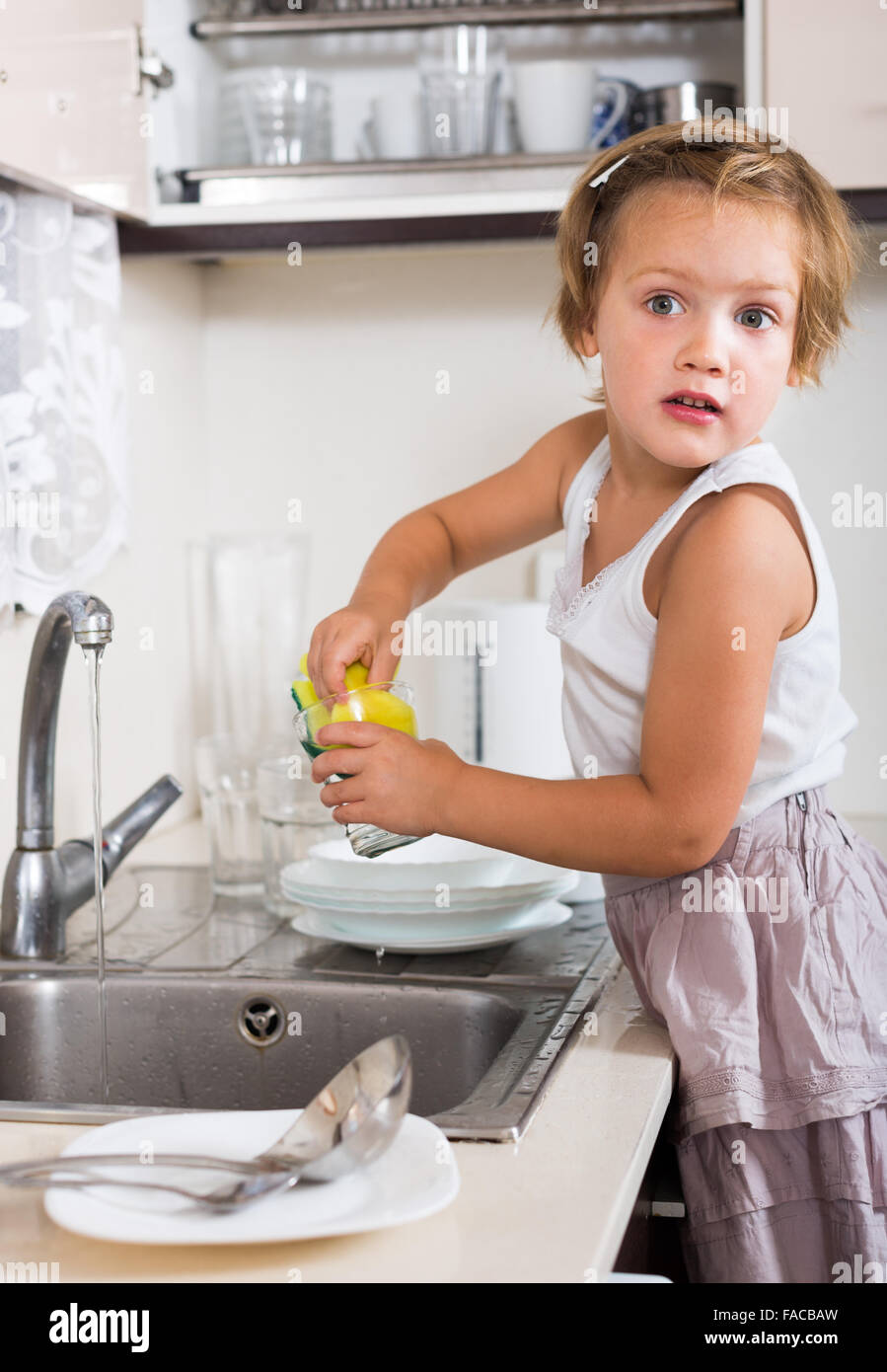 Small girl chores washing dishes at domestic kitchen Stock Photo - Alamy