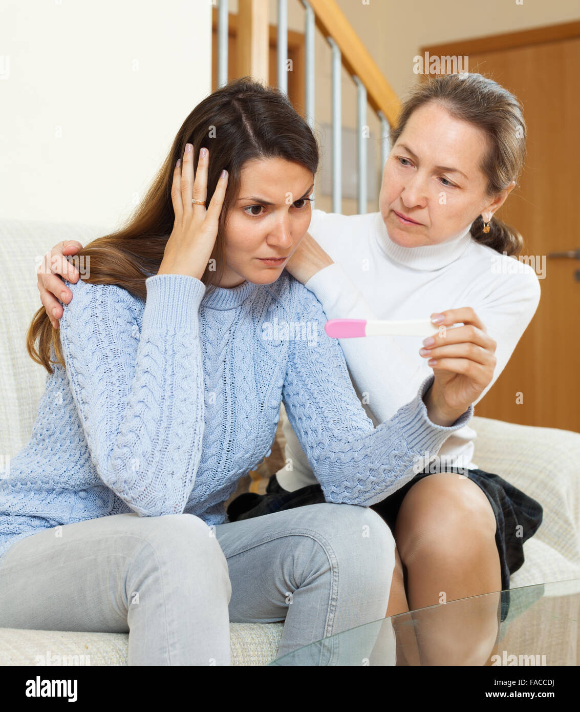 Woman consoling the worried daughter with pregnancy test at home Stock ...