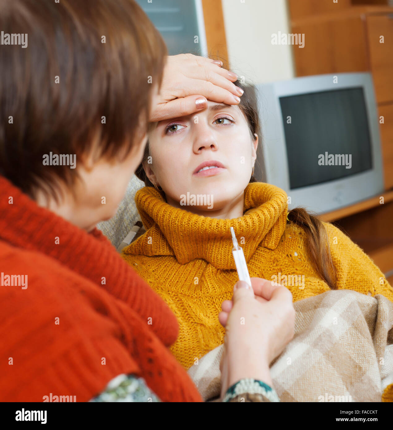 Caring woman measuring temperature with thermometer for cold adult ...