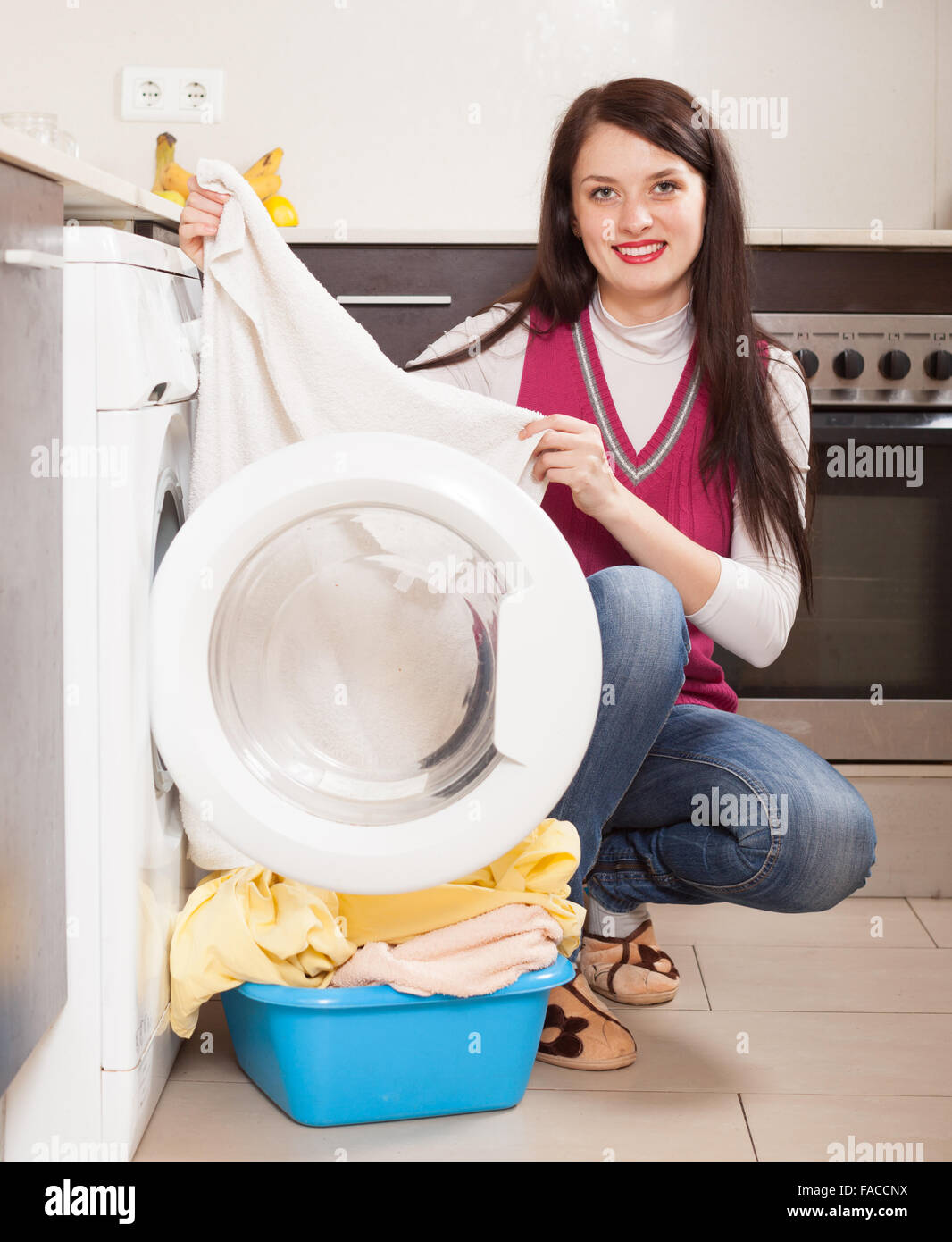 brunette girl doing laundry with washing machine Stock Photo - Alamy