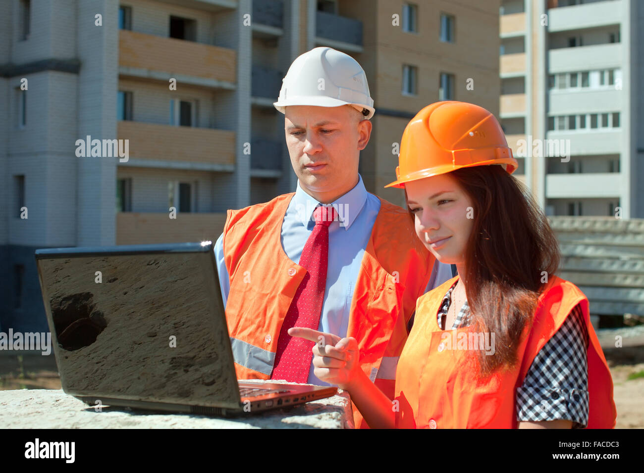 Portrait of two builders works at construction site Stock Photo - Alamy
