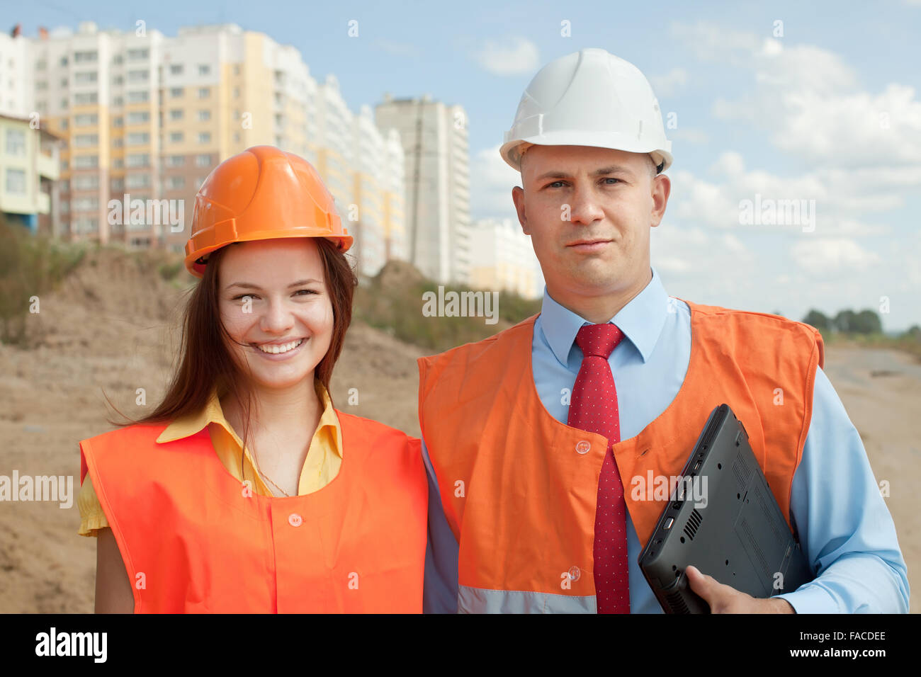 Portrait of two builders standing at building site Stock Photo - Alamy