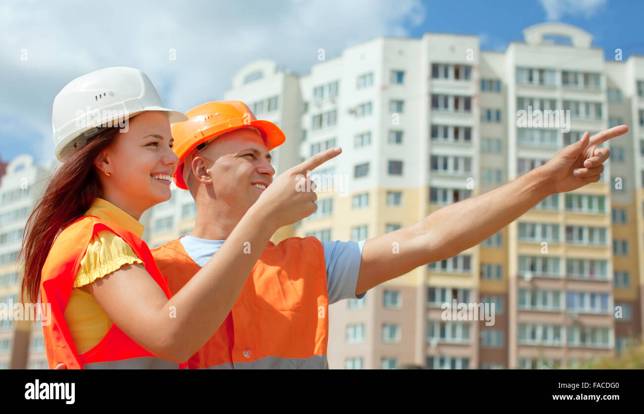 Portrait of two builders standing at building site Stock Photo - Alamy
