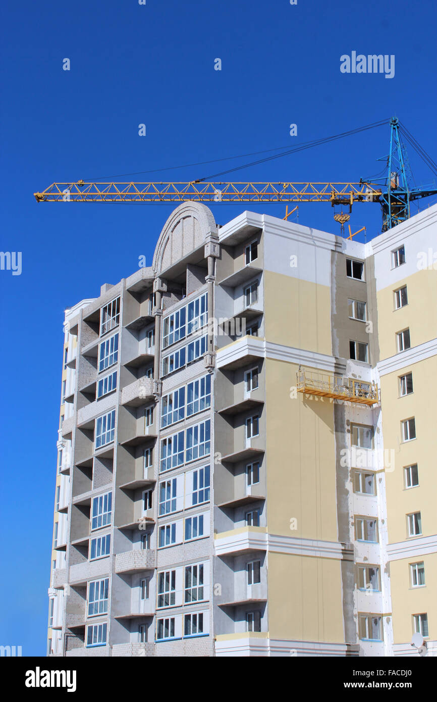 construction of multistory modern house with hoisting crane on the blue ...