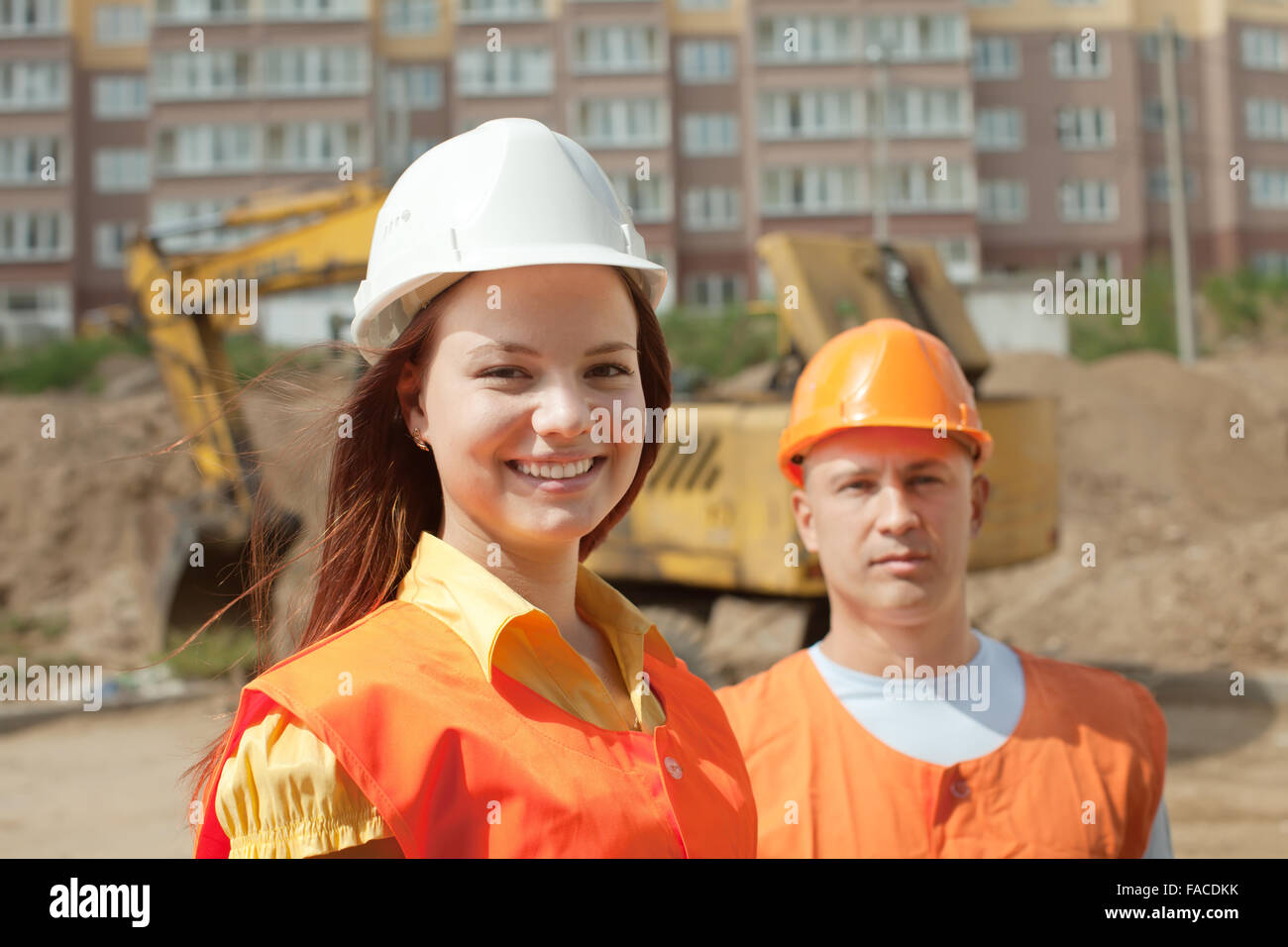 Portrait of two builders works at building site Stock Photo - Alamy