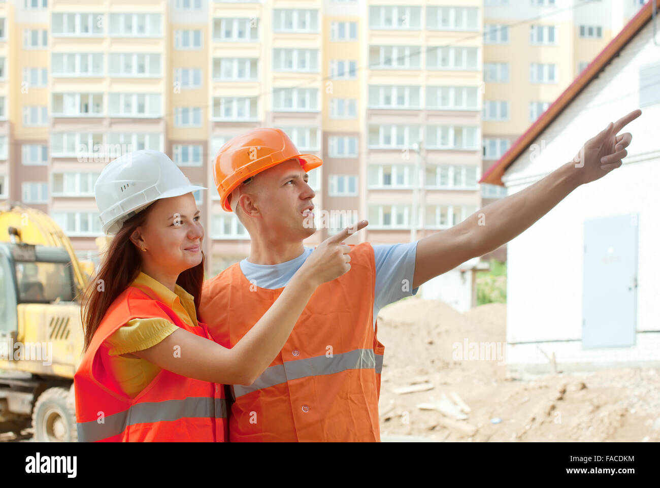 Portrait of two builders standing at building site Stock Photo - Alamy