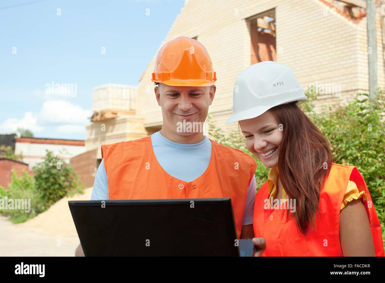 Portrait of two builders works at building site Stock Photo - Alamy