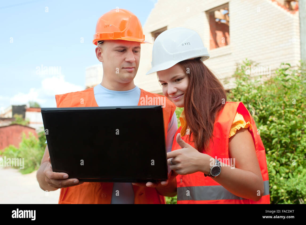 Portrait of two builders works at building site Stock Photo - Alamy