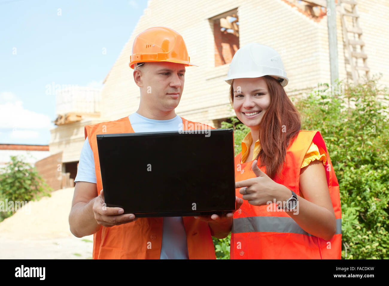 Portrait of two builders works at building site Stock Photo - Alamy