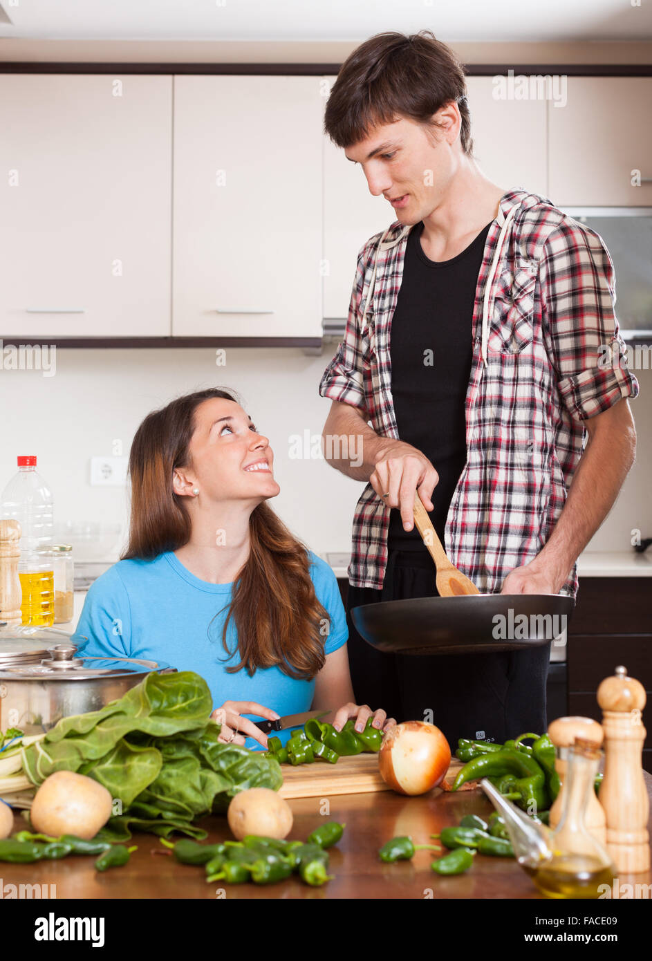young man and pretty girl cooking together in kitchen Stock Photo - Alamy