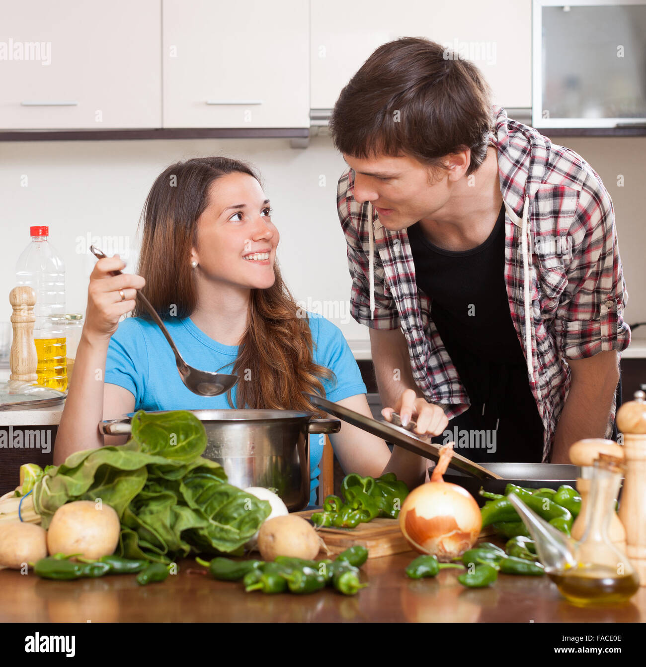Guy and smile girl cooking in domestic kitchen Stock Photo - Alamy