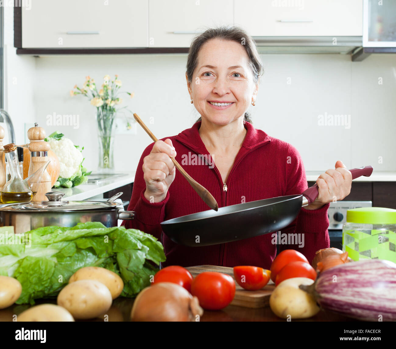 mature woman cooking with skillet in domestic kitchen Stock Photo - Alamy