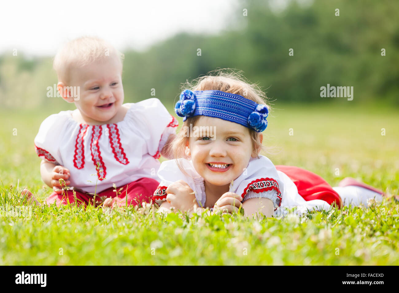 Happy children in russian folk clothes on grass meadow Stock Photo - Alamy