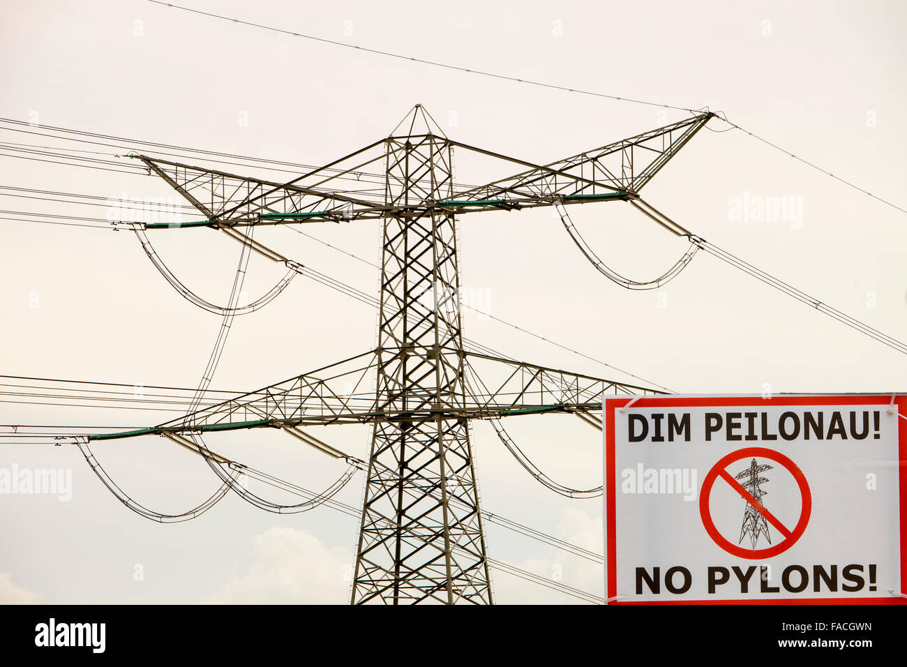 Pylons carrying electricty and protest sign Stock Photo - Alamy