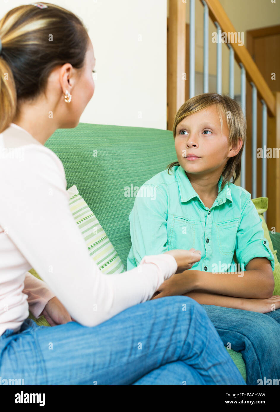 mother and teen boy talking in home interior. Focus on son Stock Photo ...