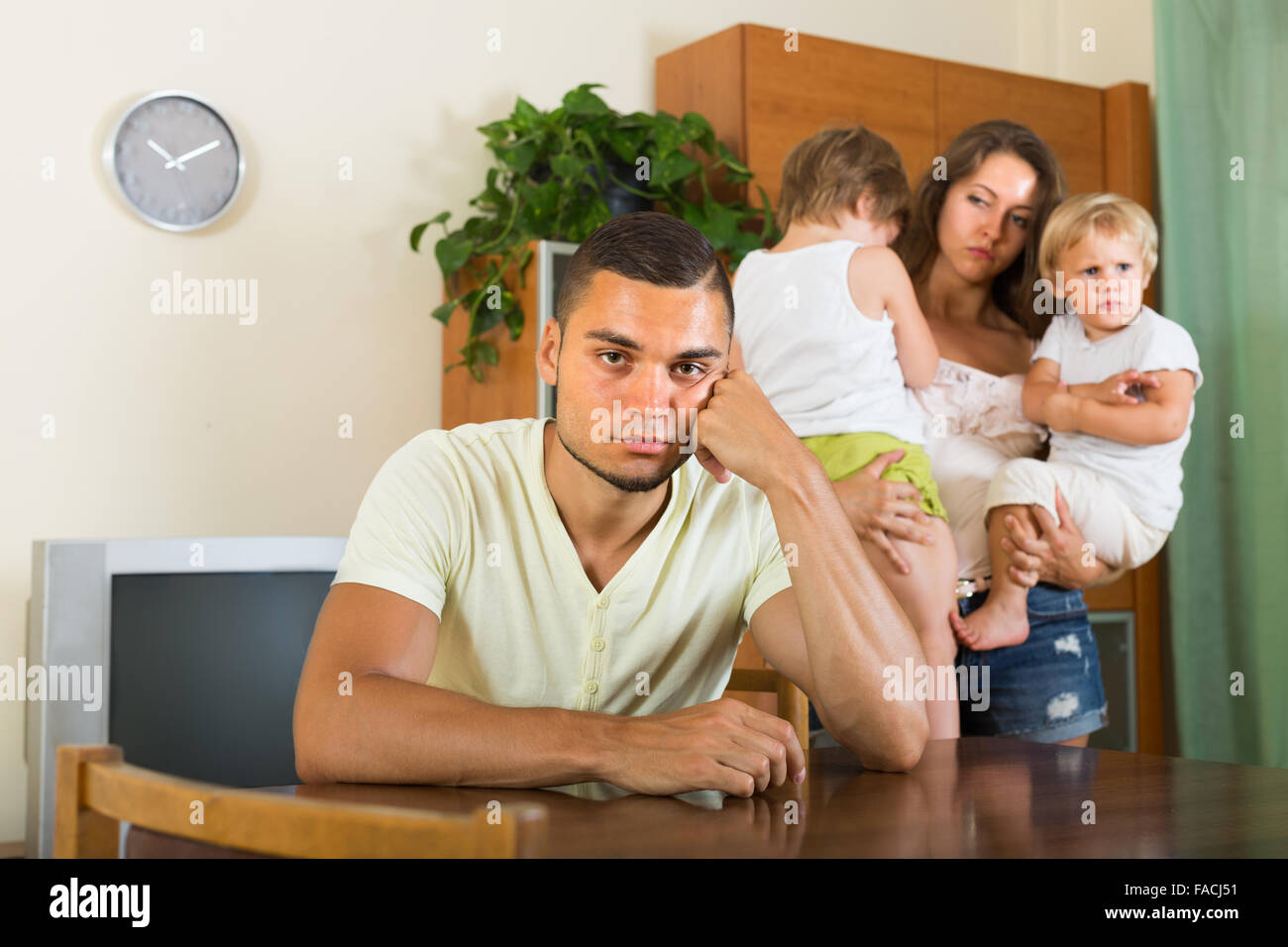 Quarrel between young parents with two little children at home Stock ...