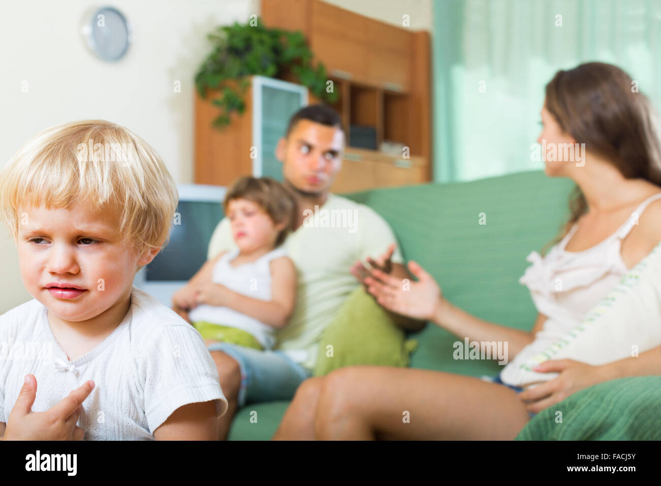 Young family with two little daughters having conflict at home. Focus ...