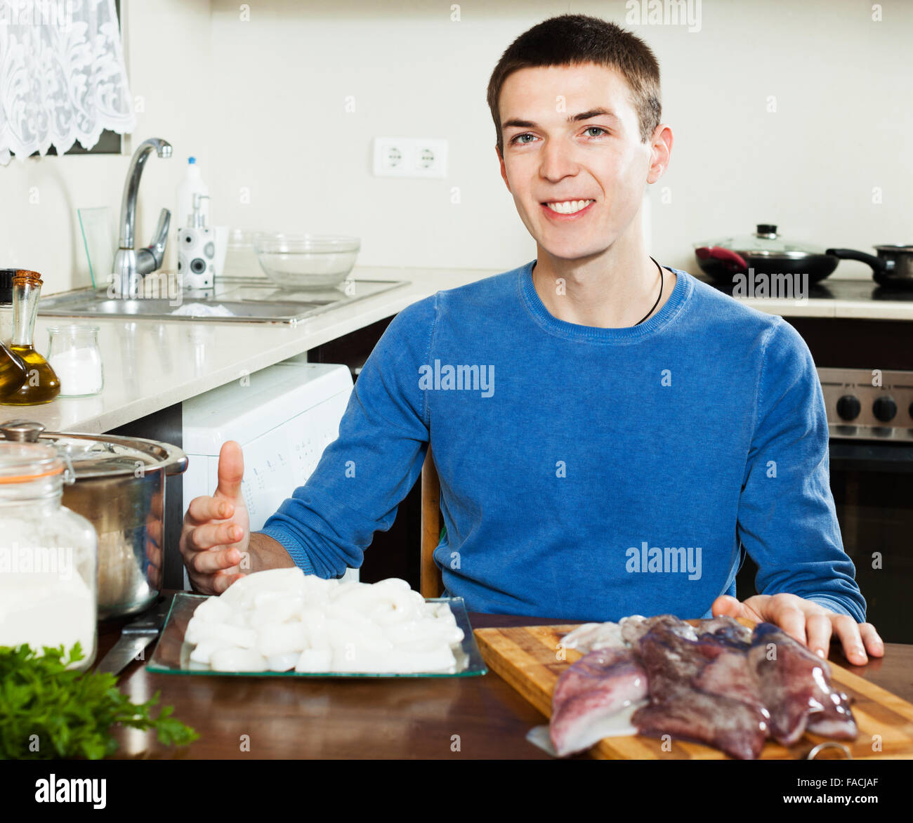 Ordinary man cooking raw squid in kitchen Stock Photo - Alamy