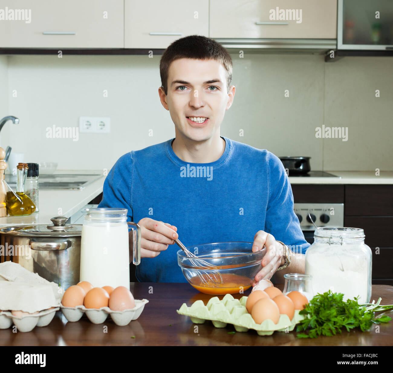 Guy cooking scrambled eggs in the kitchen Stock Photo - Alamy