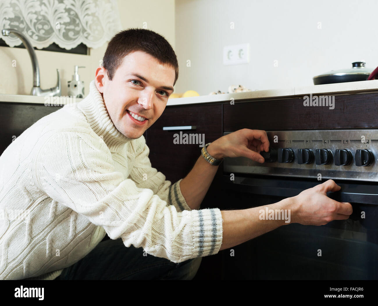 Smiling guy cooking something in the oven at home Stock Photo - Alamy