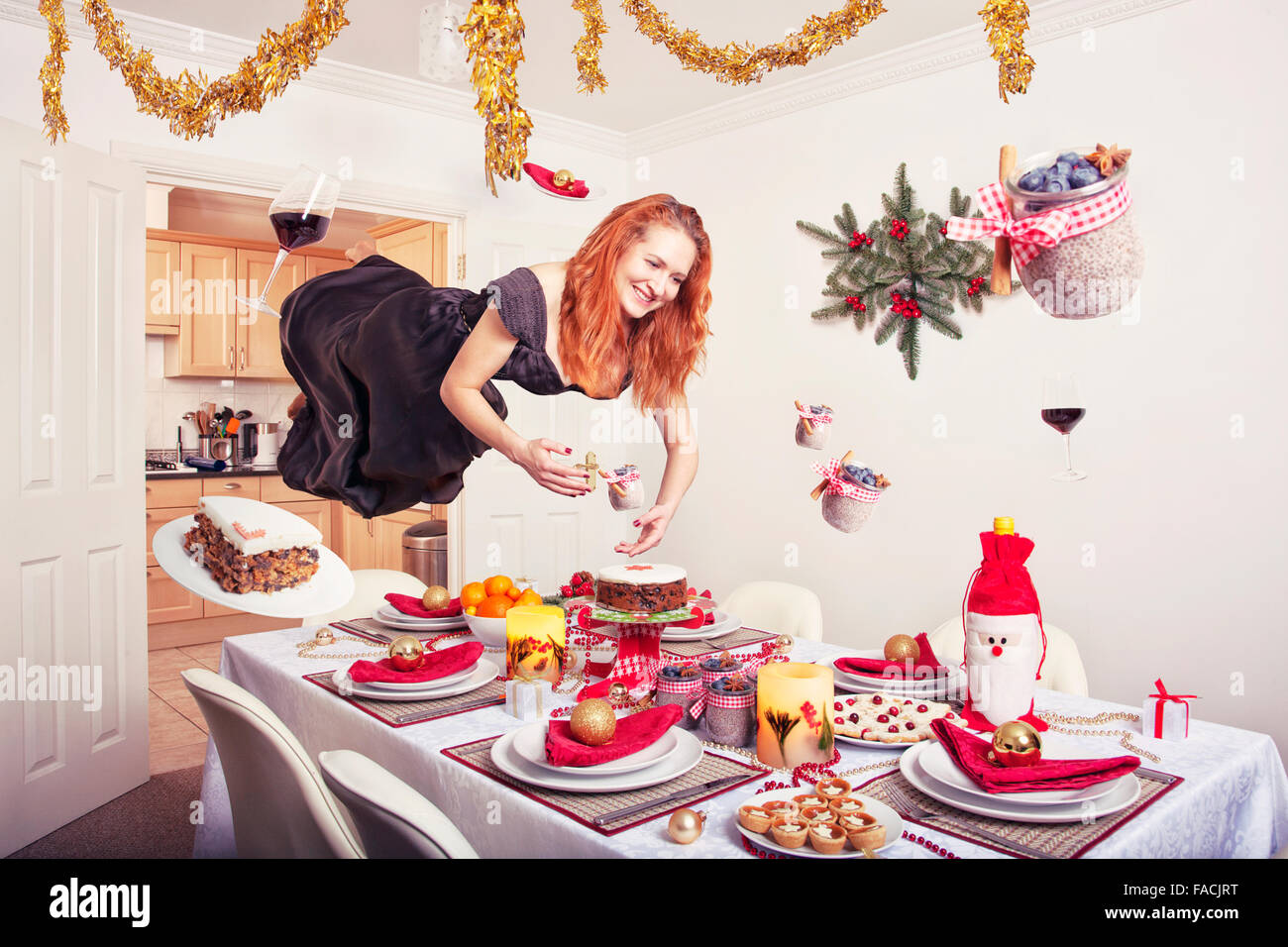 Young, cocktail dressed woman levitating with food in dining room Stock ...