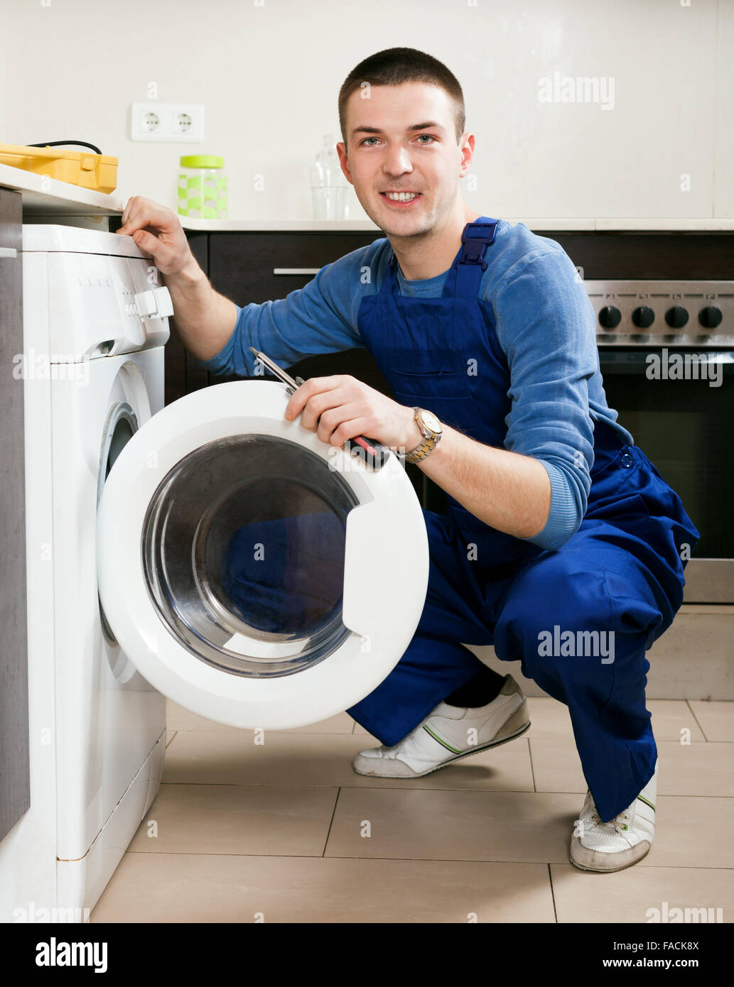 Service worker repairing washing machine Stock Photo - Alamy
