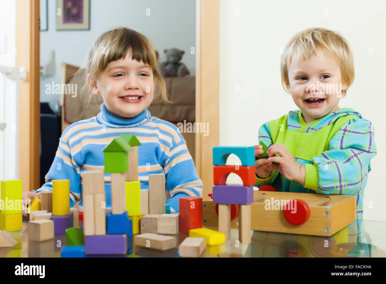 cheerful sibling playing in blocks in home interior Stock Photo - Alamy