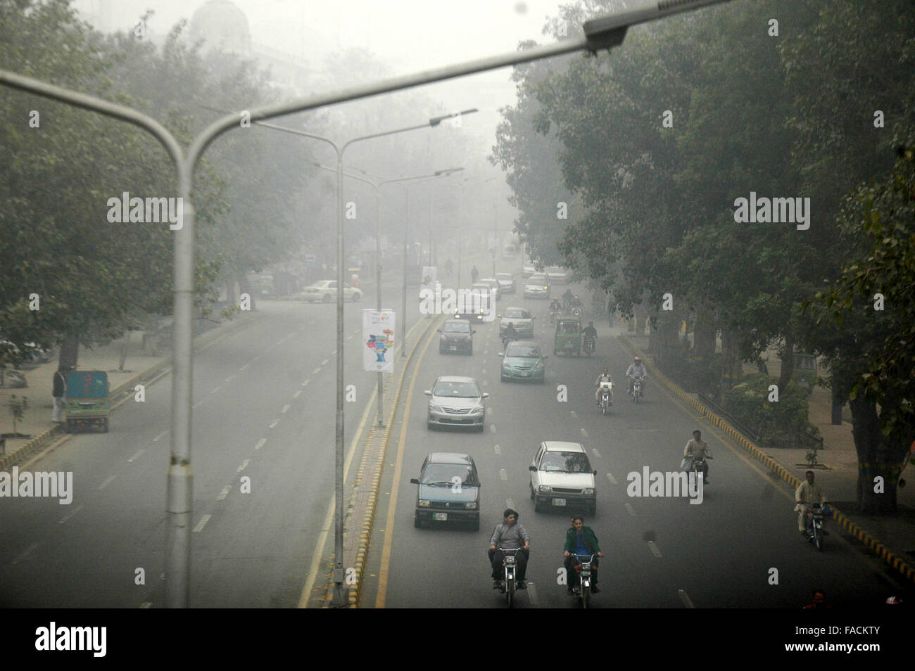 Lahore. 27th Dec, 2015. Vehicles move on a road in heavy fog in Lahore ...