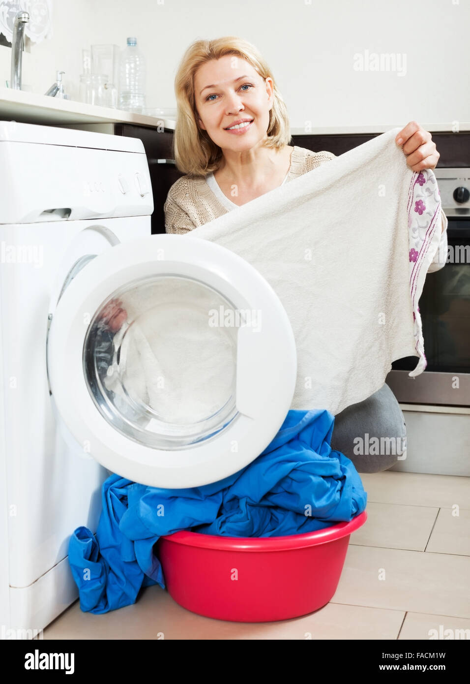 Mature housewife loading washing machine hi-res stock photography and ...