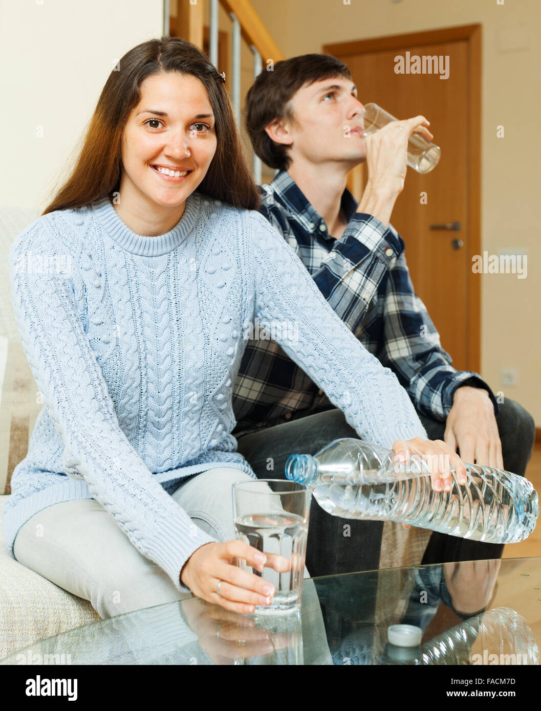 Cherful ordinary couple drinking water at home Stock Photo - Alamy