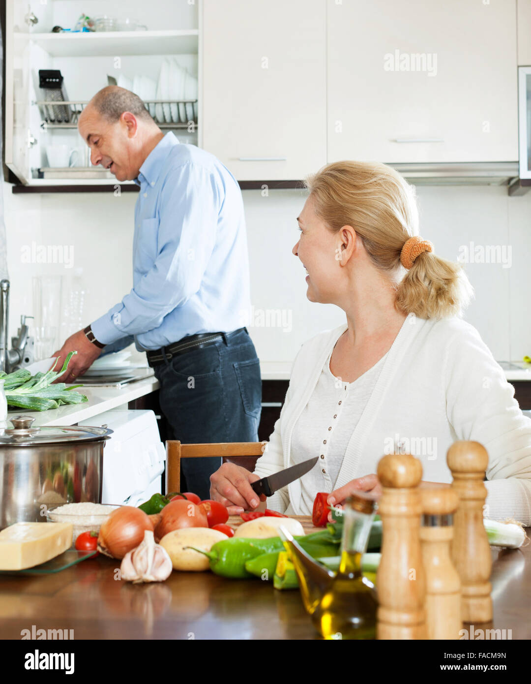Loving elderly couple doing housework and cooking together in domestic ...