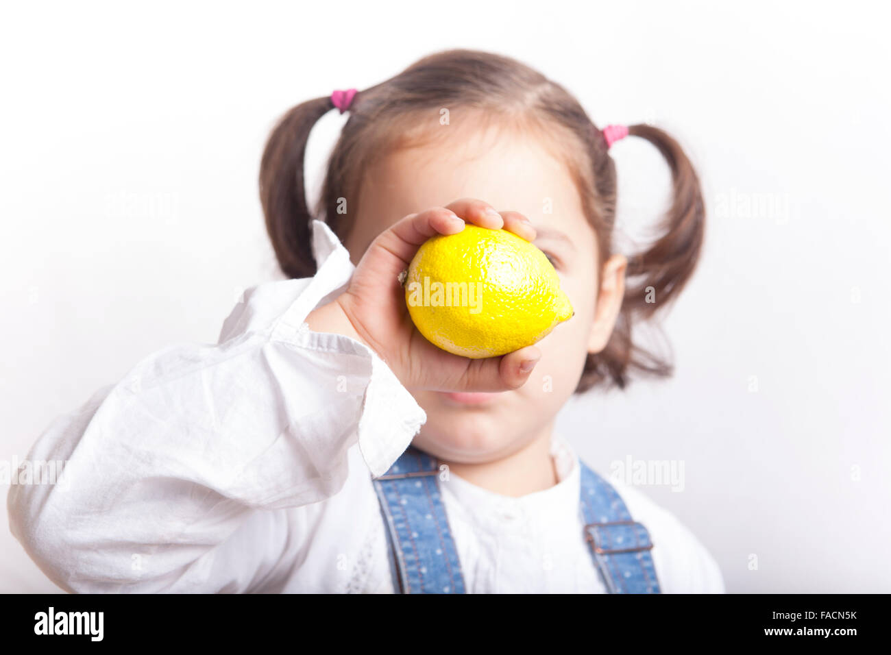 Portrait of happy girl showing a lemon. Isolated over white background ...