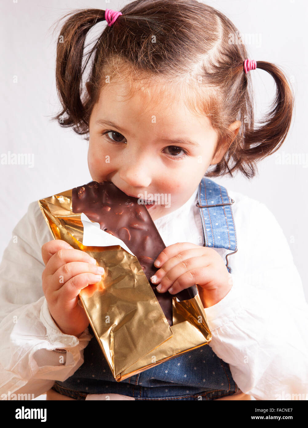 Portrait of happy girl eating chocolate. Isolated over white background ...