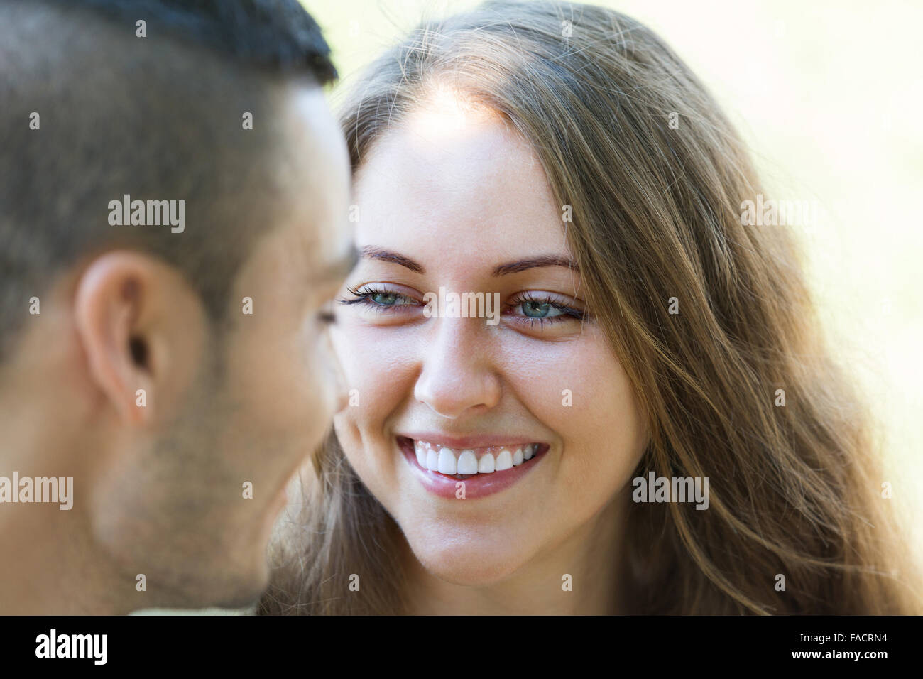 Close-up portrait of young girl and her boyfriend laughing in summer ...