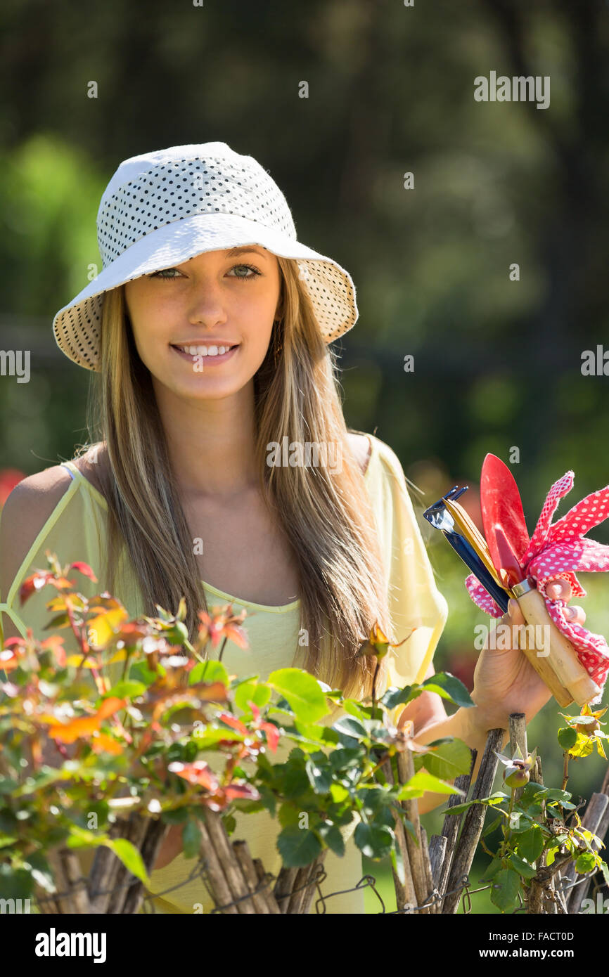 Smiling pretty girl in panama hat working in the garden Stock Photo - Alamy