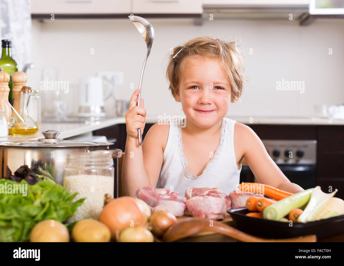 Happy baby girl cooking with meat at home Stock Photo - Alamy