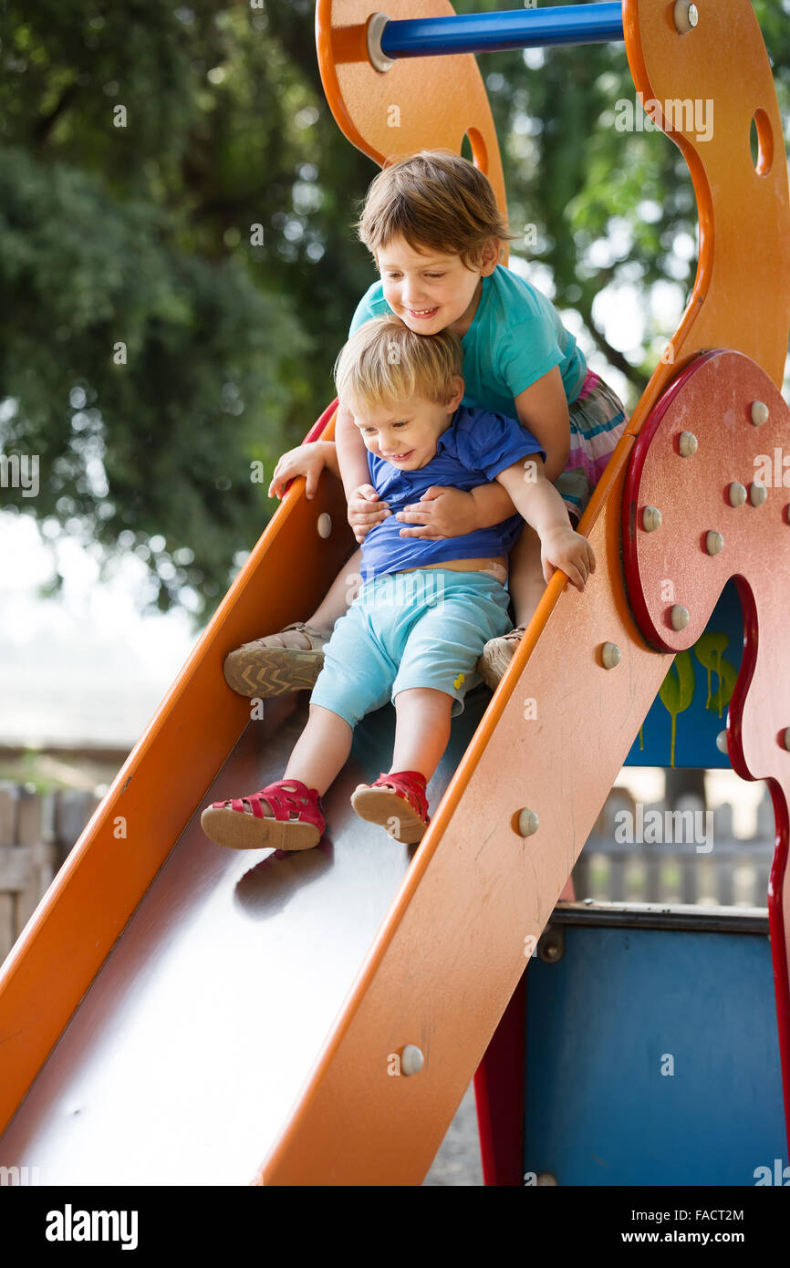 happy children on slide at playground Stock Photo - Alamy